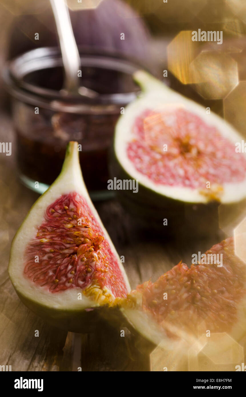 Sliced fig and glass of fig jam om wooden table Stock Photo - Alamy