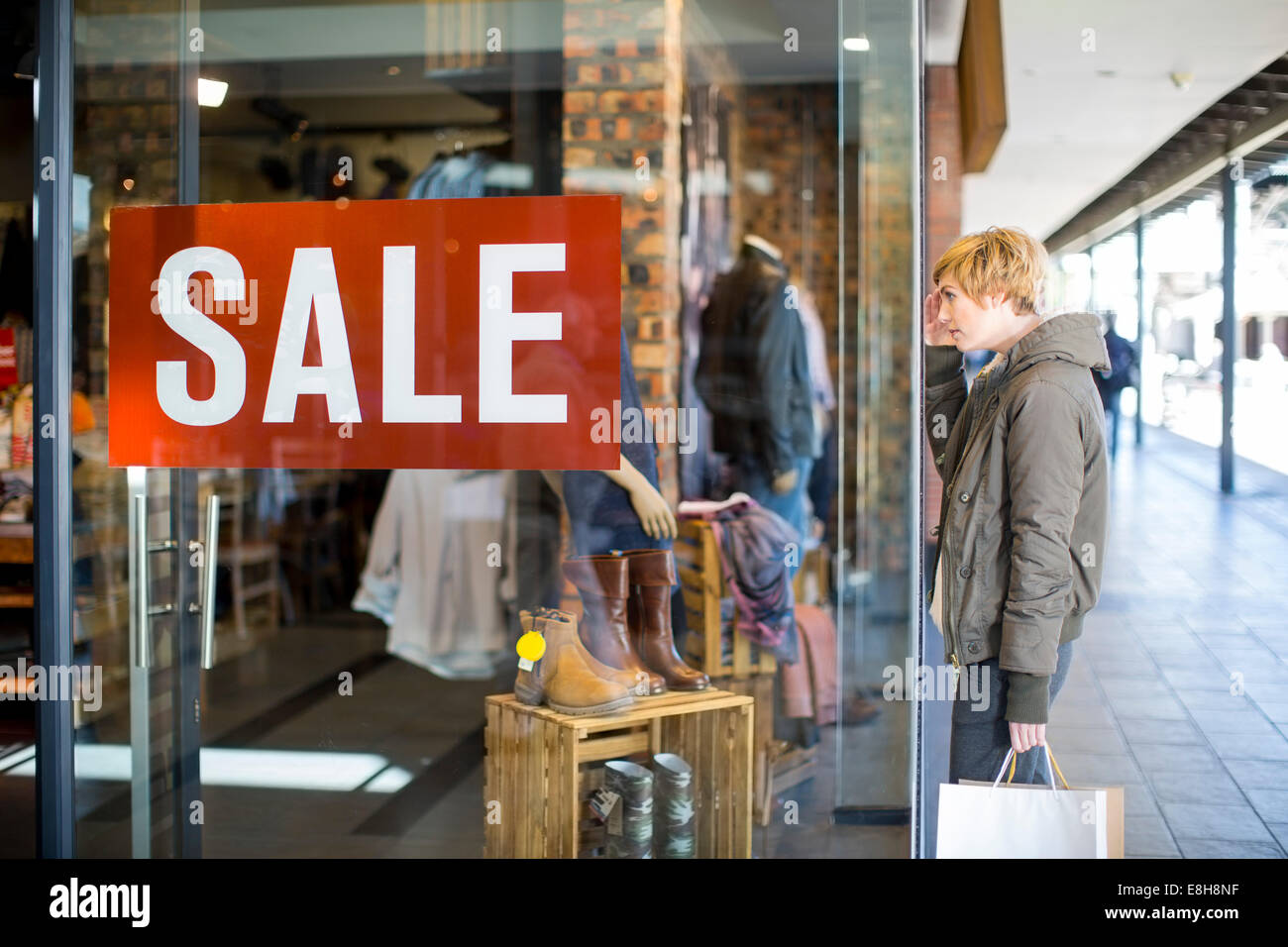 Woman looking through a window display Stock Photo - Alamy