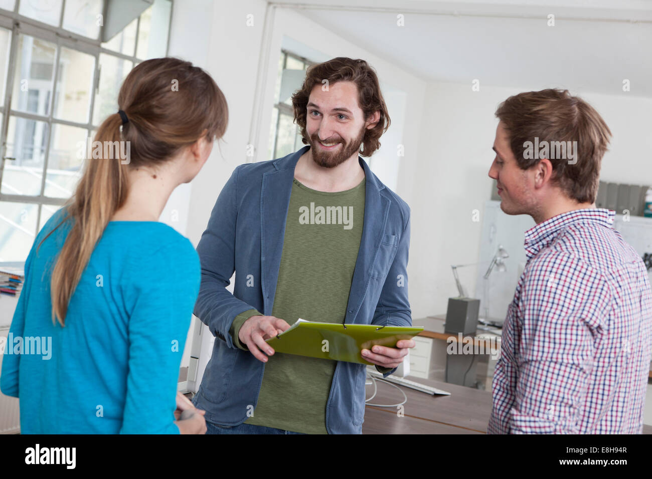 Three colleagues in an office discussing something Stock Photo - Alamy