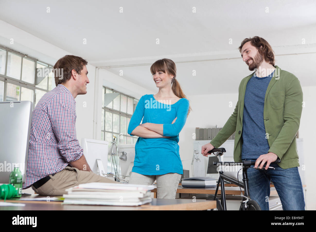 Three colleagues talking together in an office Stock Photo - Alamy