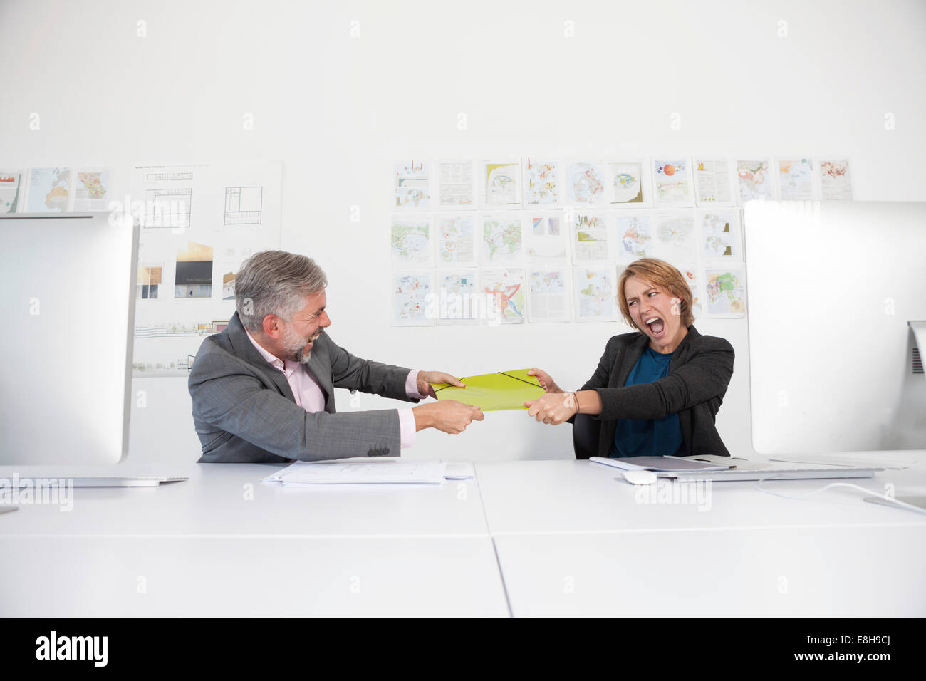 Two quarreling colleagues at their desks in an office Stock Photo - Alamy