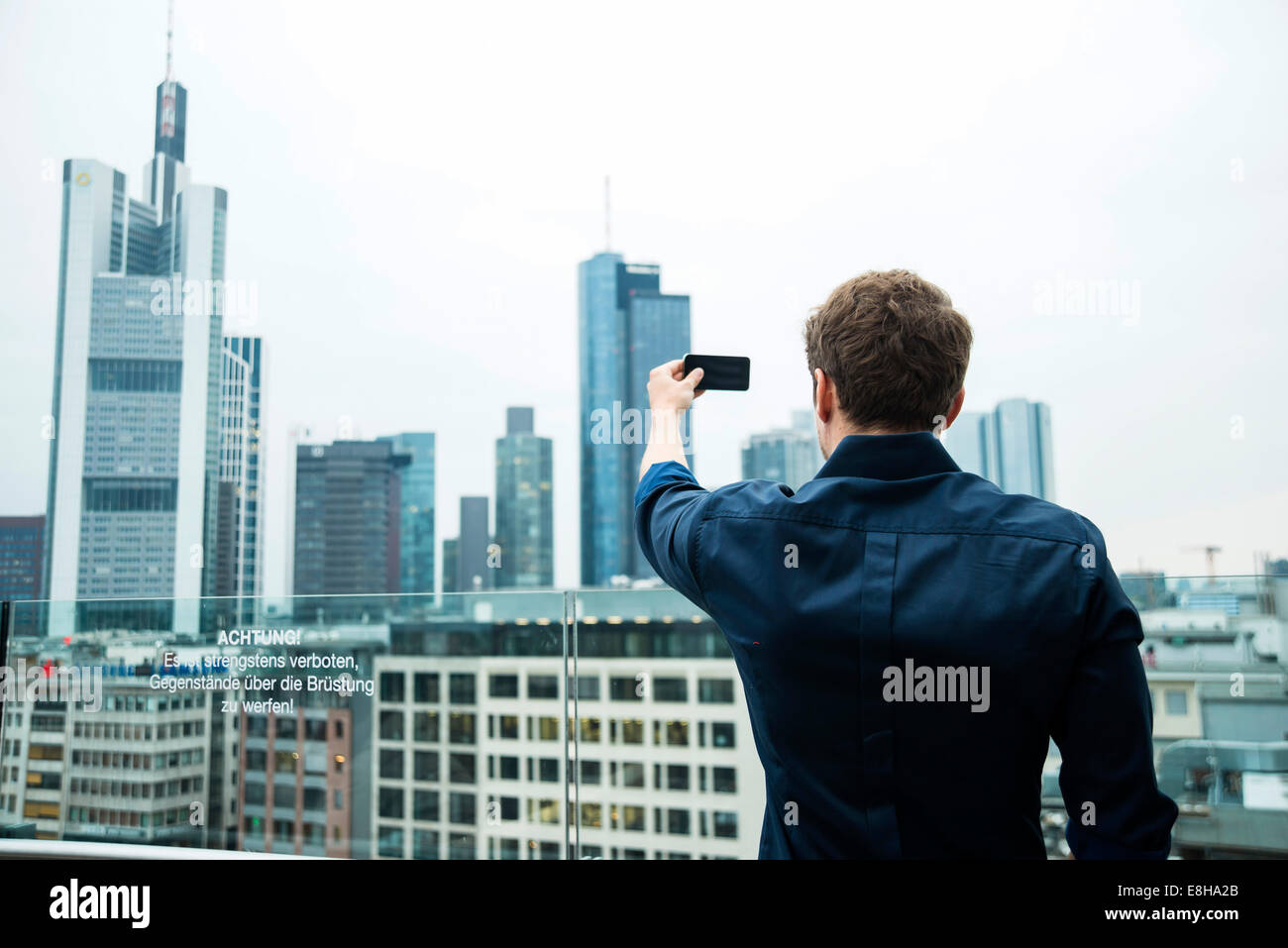 Germany, Hesse, Frankfurt, young man taking a picture of the skyline ...