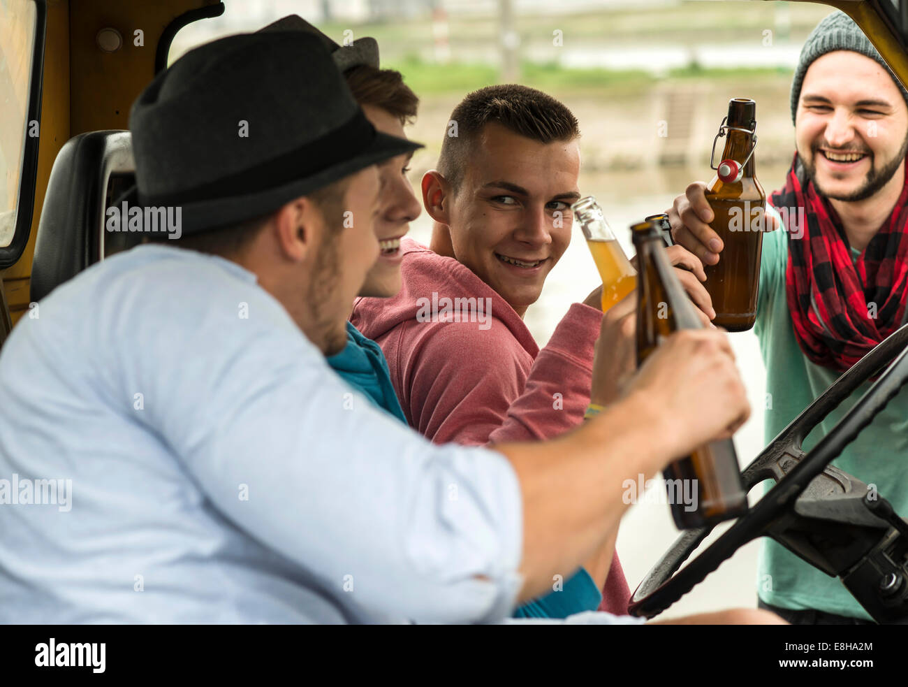 Group of friends drinking beer in car Stock Photo - Alamy