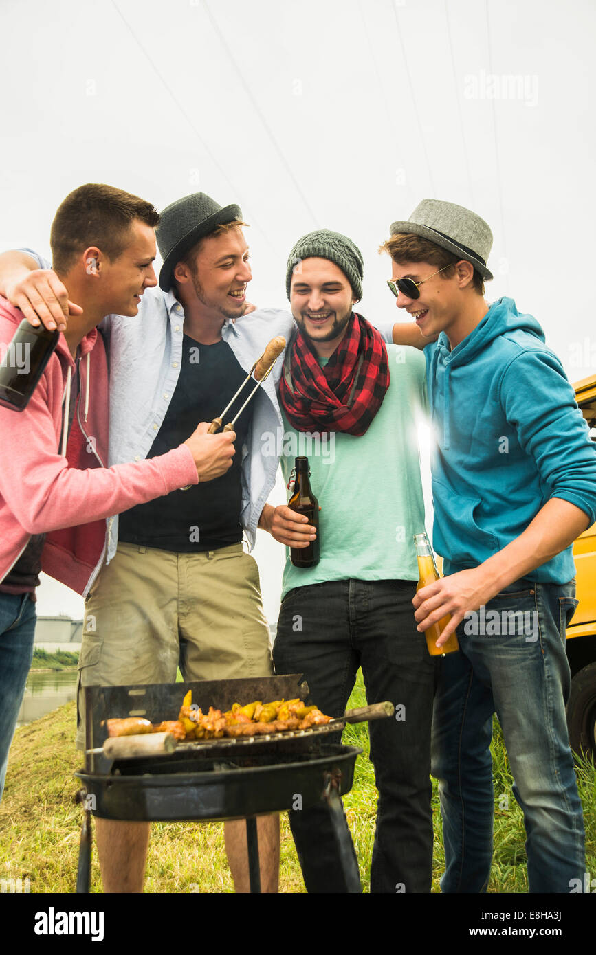 Group of friends drinking beer and having a barbecue Stock Photo - Alamy