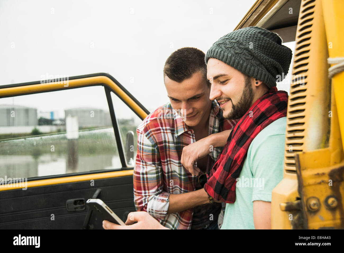Two friends with cell phone at a car Stock Photo - Alamy