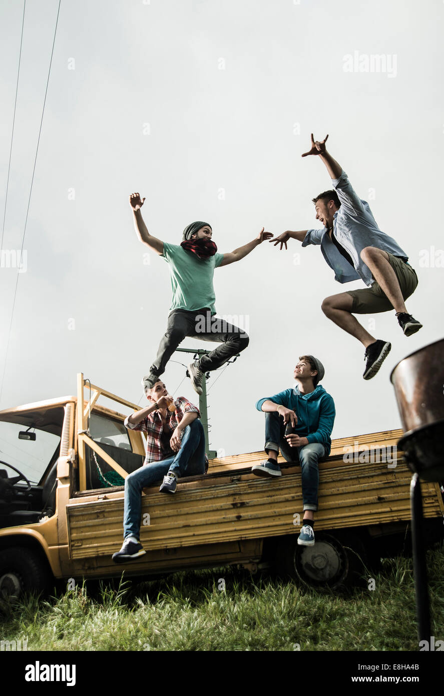 Two friends jumping from pick-up truck Stock Photo - Alamy