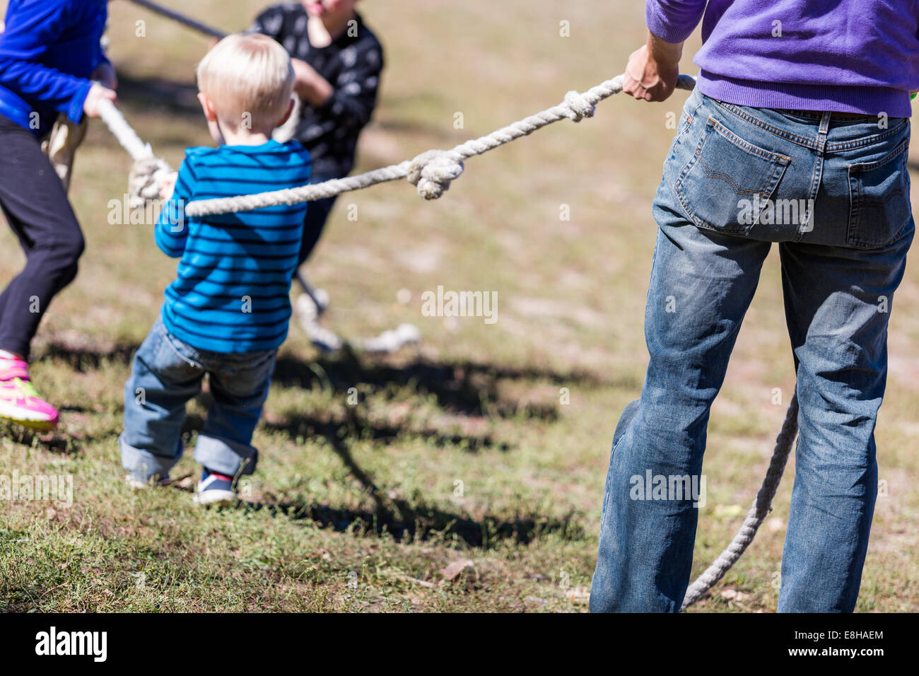 Two families playing vintage rope pulling game in the park Stock Photo ...