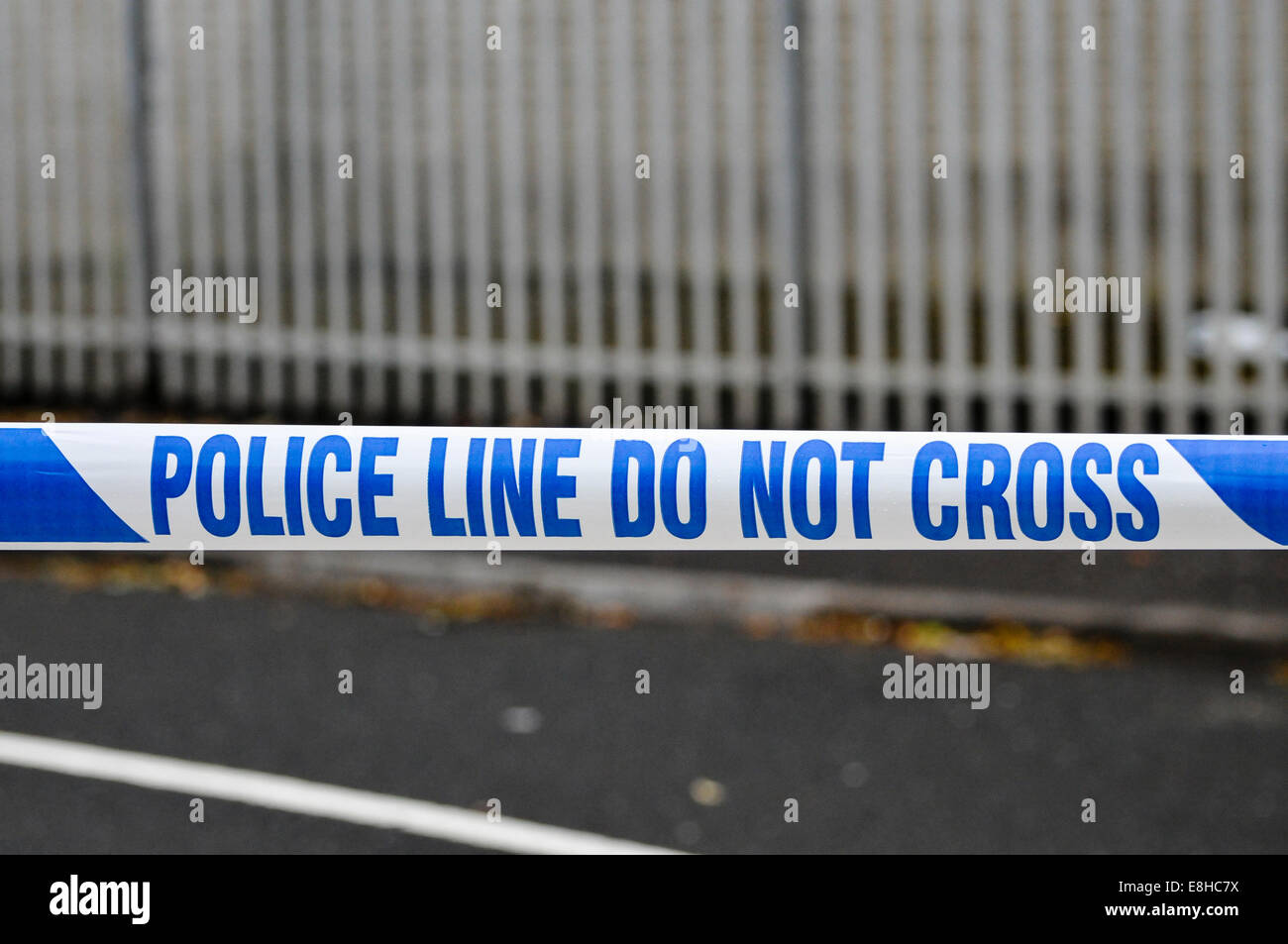 Police tape stretched across a road at a crime scene cordon point ...