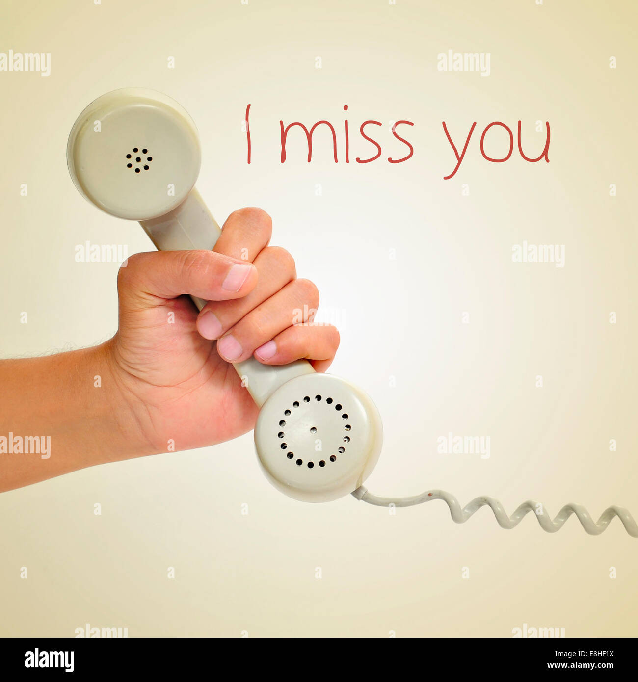 a man hand holding the handset of a telephone and the text I miss you ...