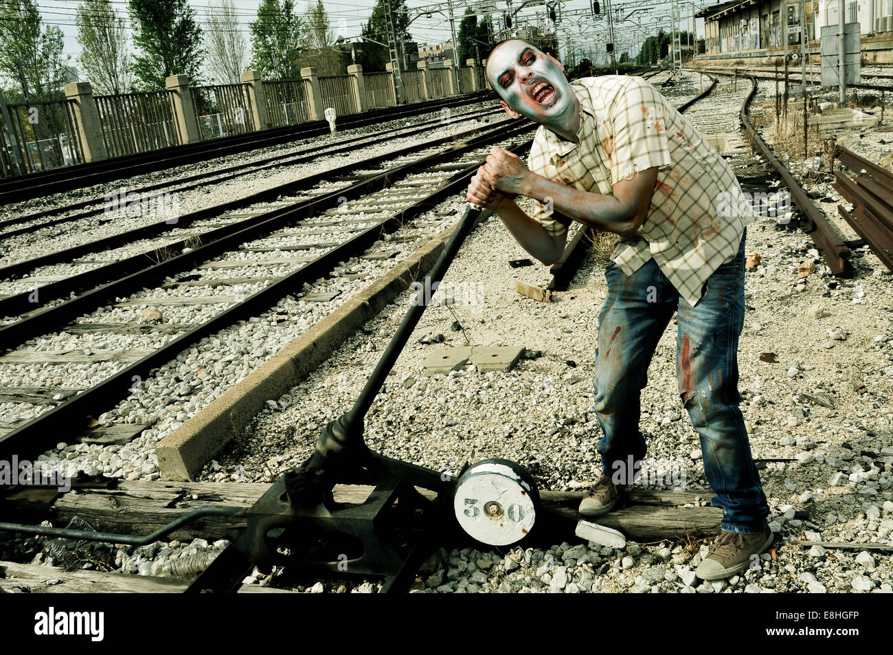 a scary zombie operating the railroad switch of the railroad tracks ...