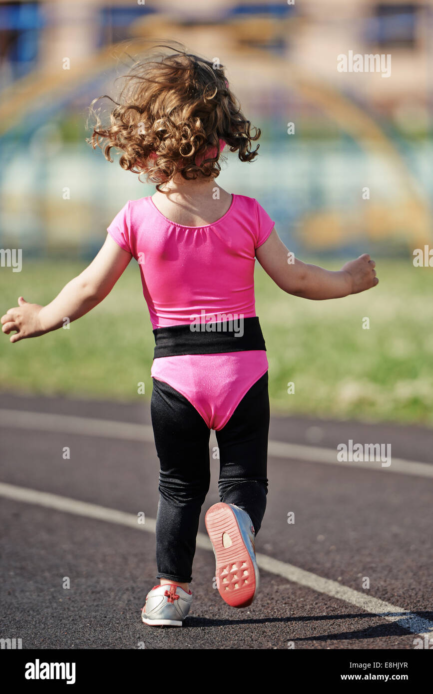 ittle cute girl running at stadium Stock Photo - Alamy