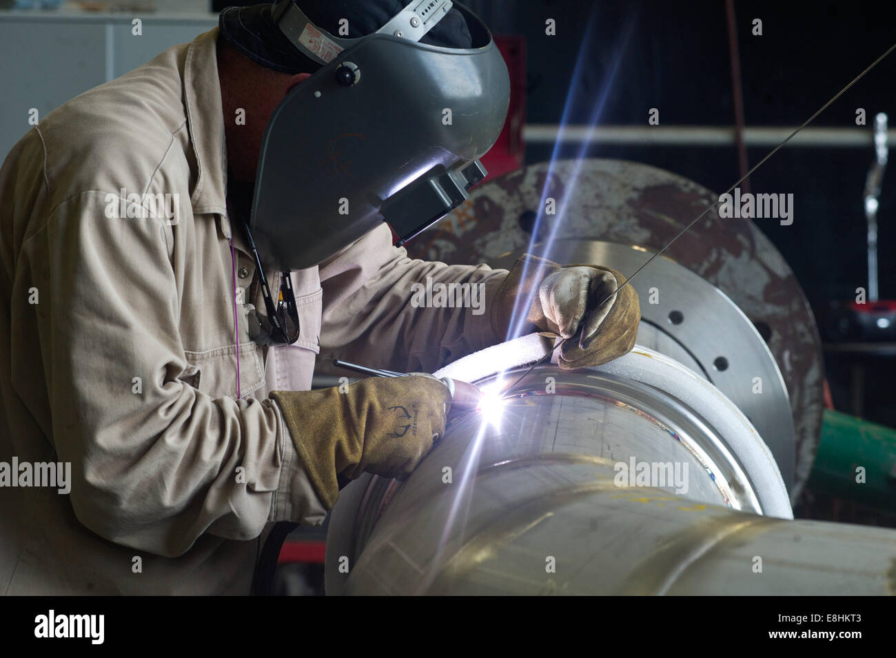A welder works on piping for the RS-25 rocket engine installation at ...