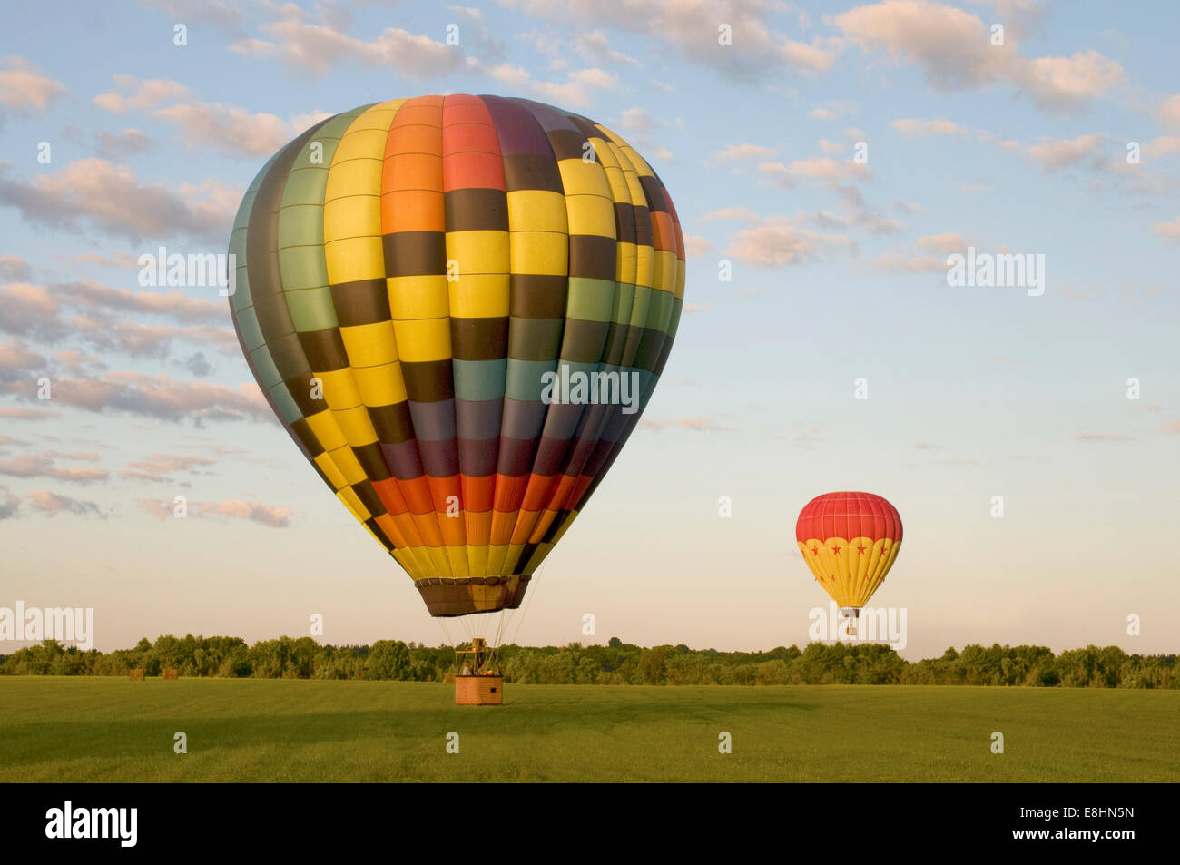 Two hot-air balloons landing in a field Stock Photo - Alamy