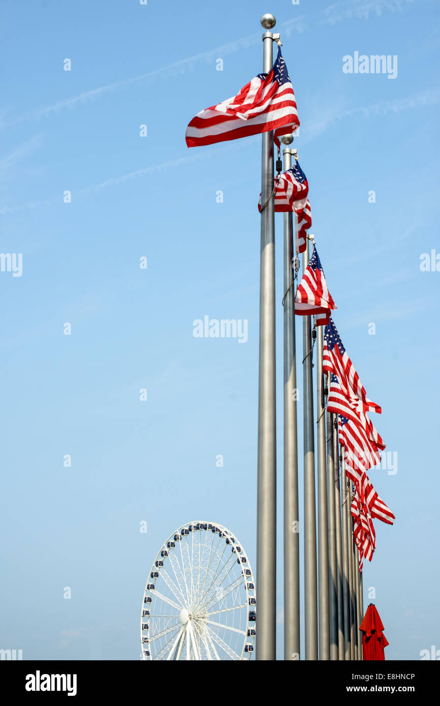 A row of flags, with a giant ferris wheel in the background, at ...