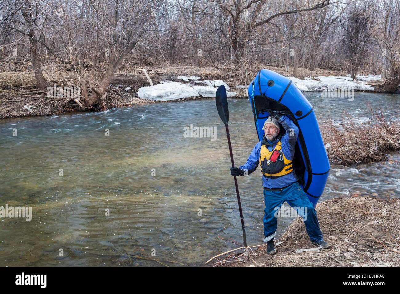 senior male carrying a packraft (one-person light raft used for ...