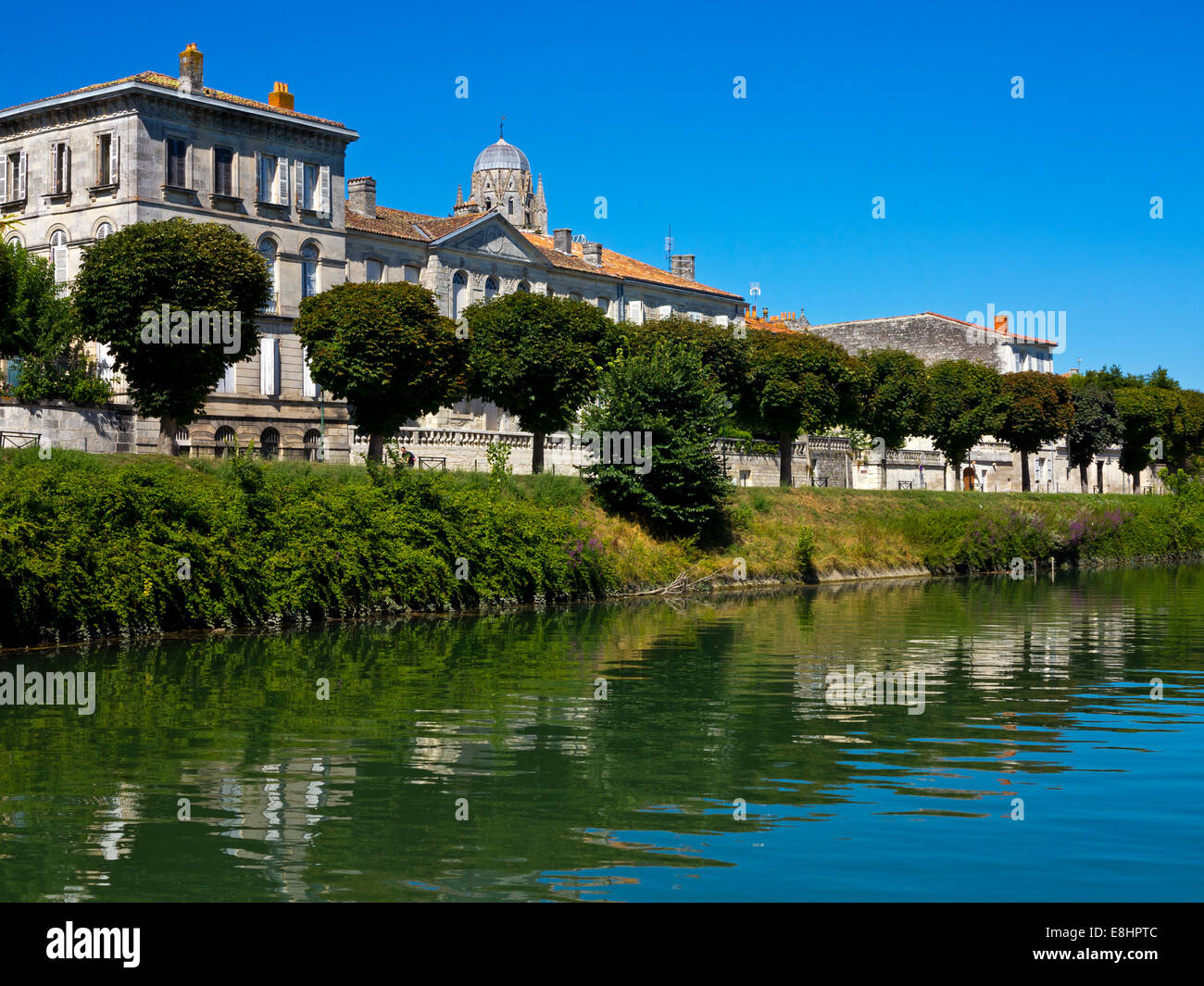 Cathedral tower and buildings reflected in River Charente at Saintes a ...
