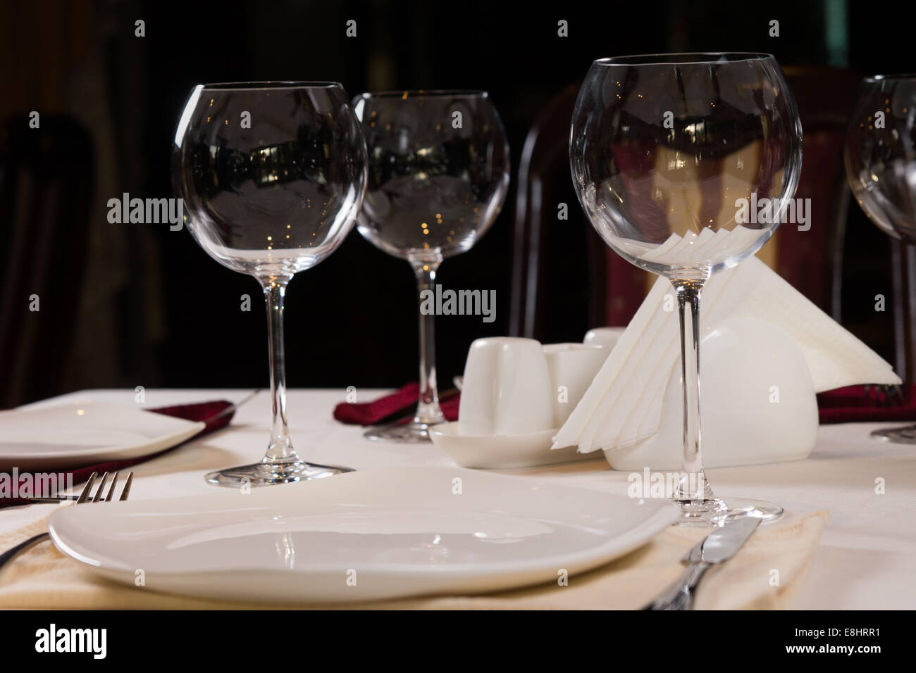 Empty plate and wineglasses on a formal dinner table in a restaurant ...