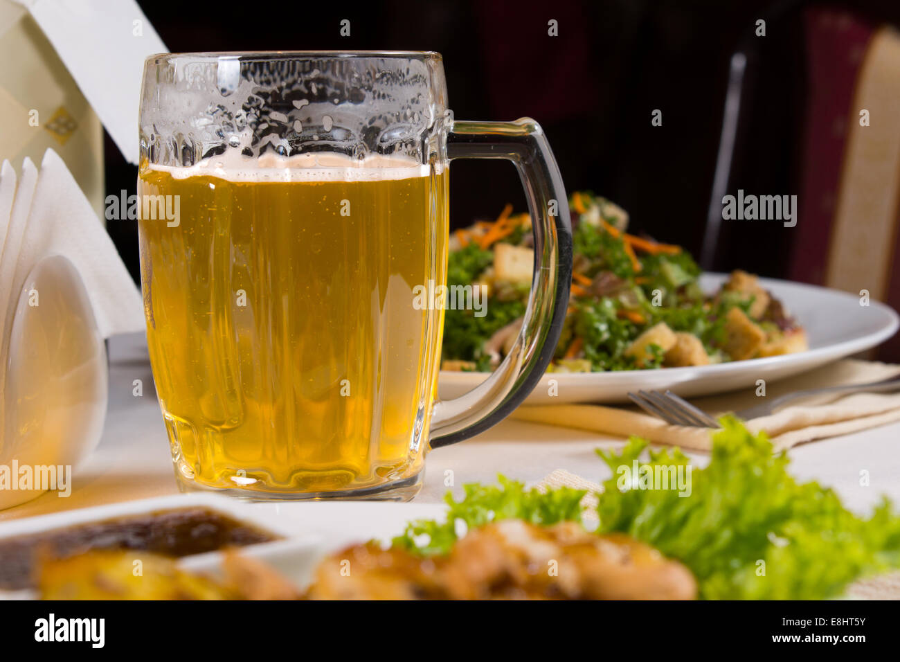 Glass Mug of Beer on Table Amongst Plates of Food on Table in ...