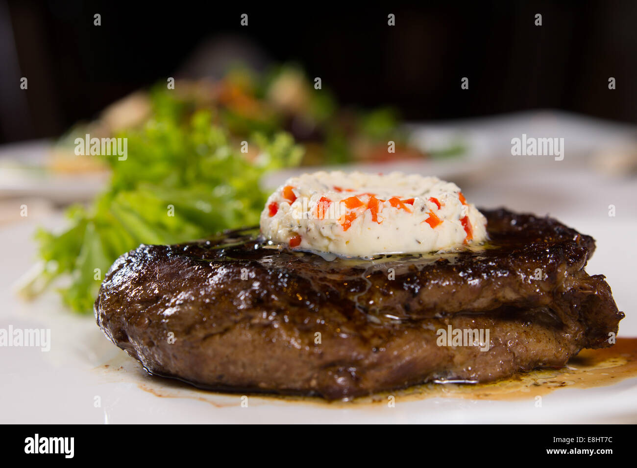 Close Up of Steak Topped with Herbed Butter and Garnish on Plate Stock ...