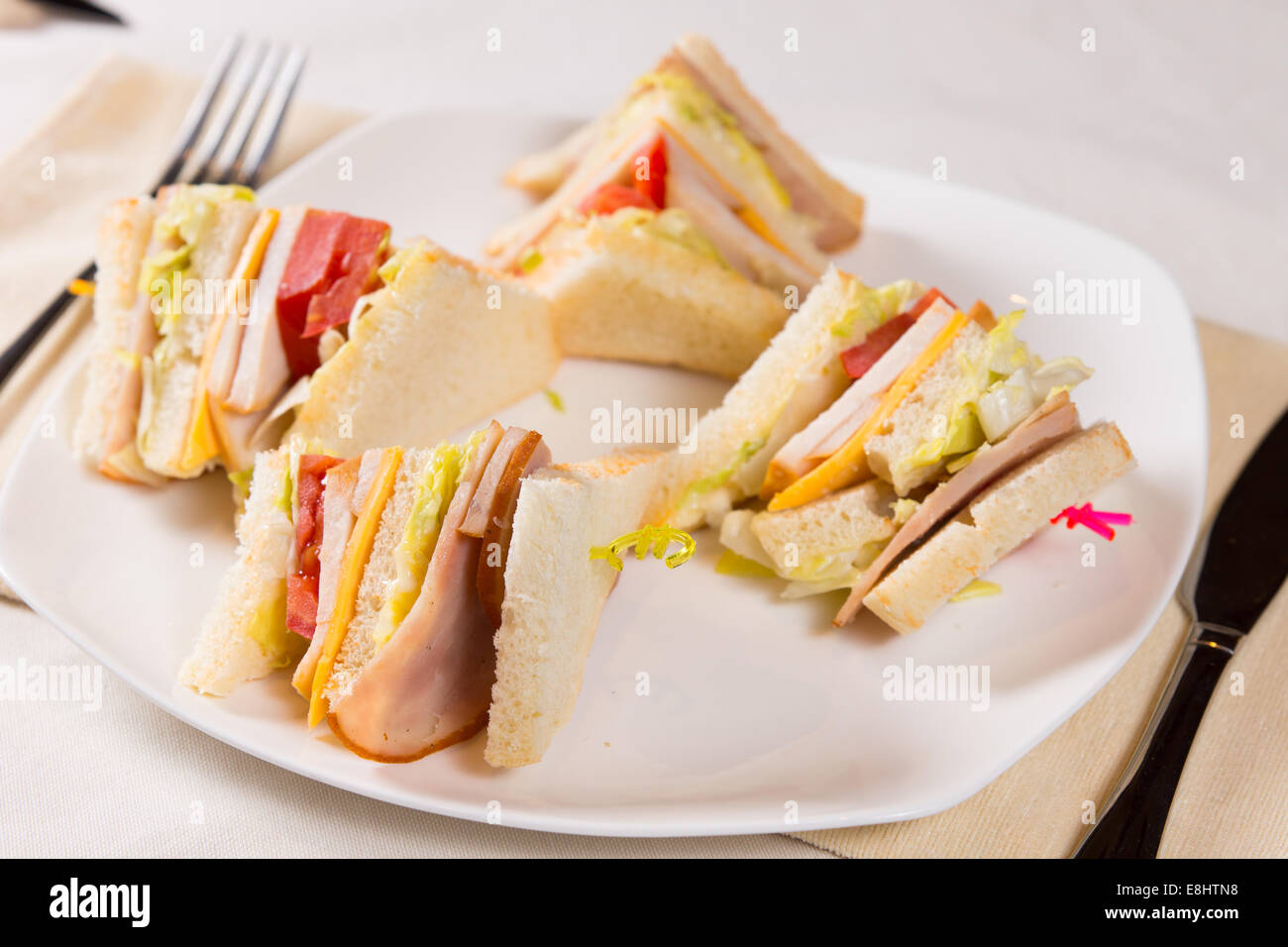 Close Up of Triple Decker Sandwich on Plate at Place Setting Stock ...