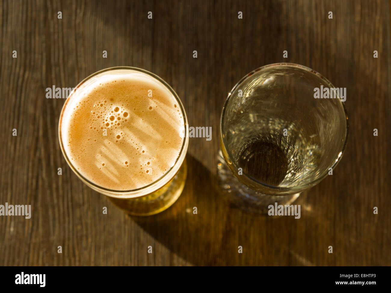 Overhead of Glass of Beer Beside Empty Glass on Wooden Table Stock ...