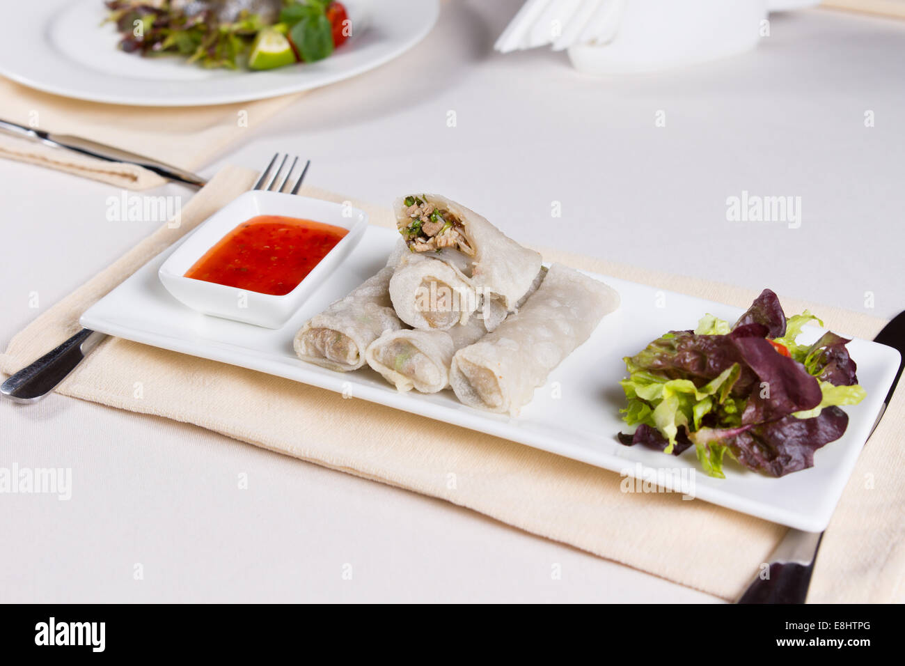 Stack of Spring Rolls with Sauce and Garnish on Plate on Restaurant ...