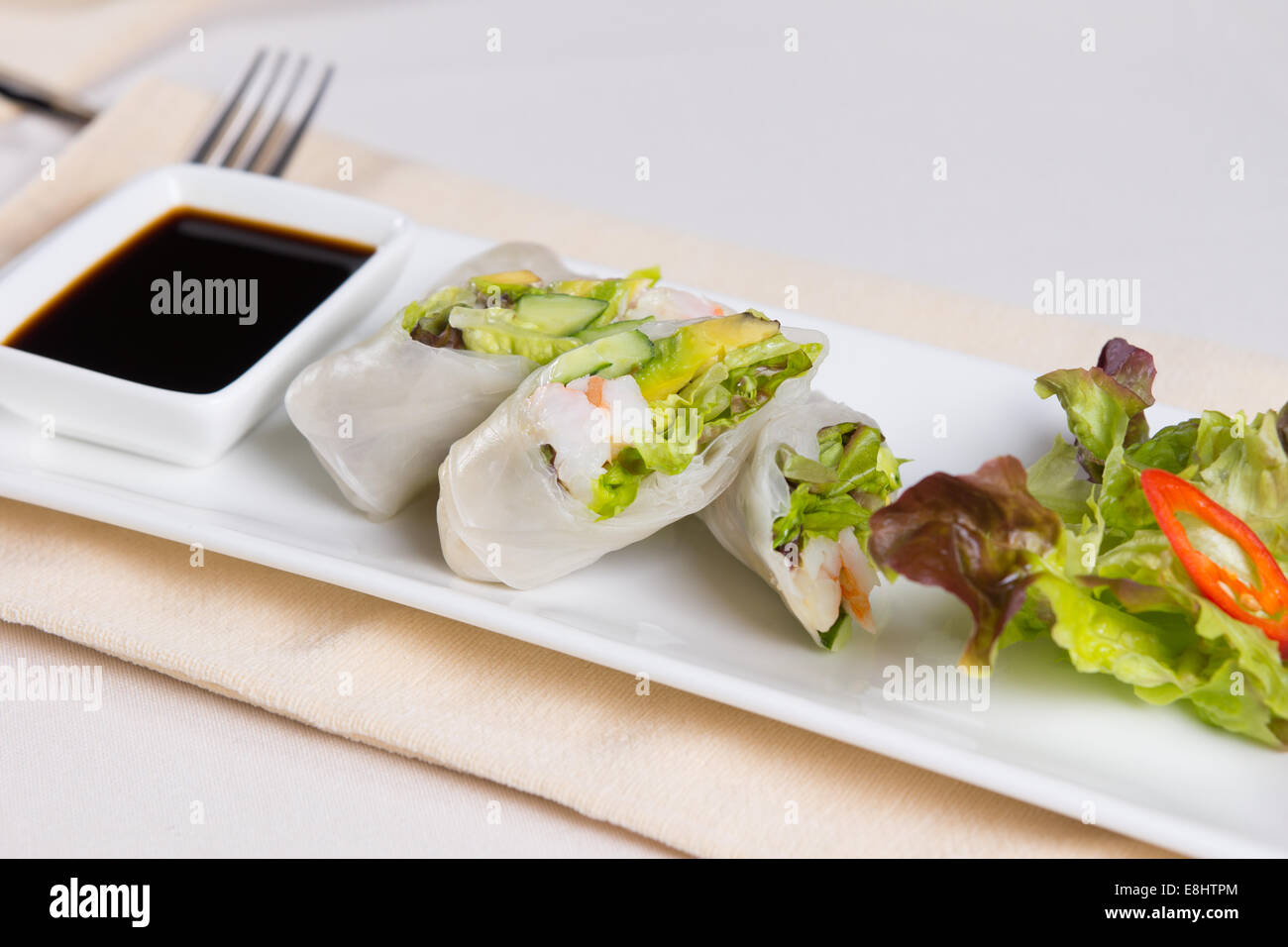 Cut Rice Paper Rolls on Plate with Garnishes Stock Photo - Alamy