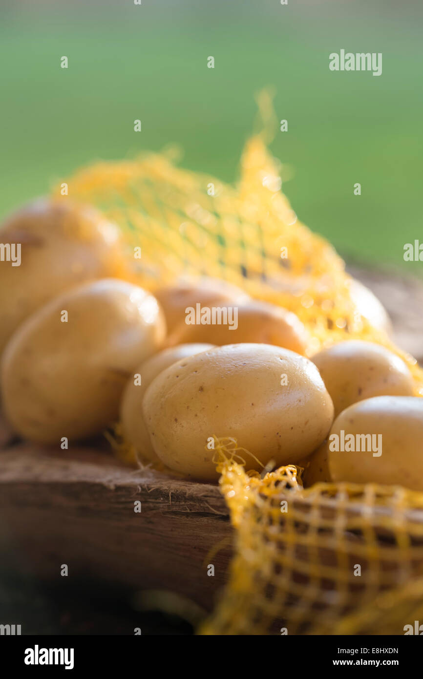 group of whole potatoes on rustic wood within carry net Stock Photo - Alamy