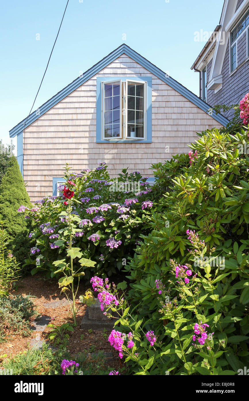 Flowers frame a view of a peaked roof and open window in Provincetown ...