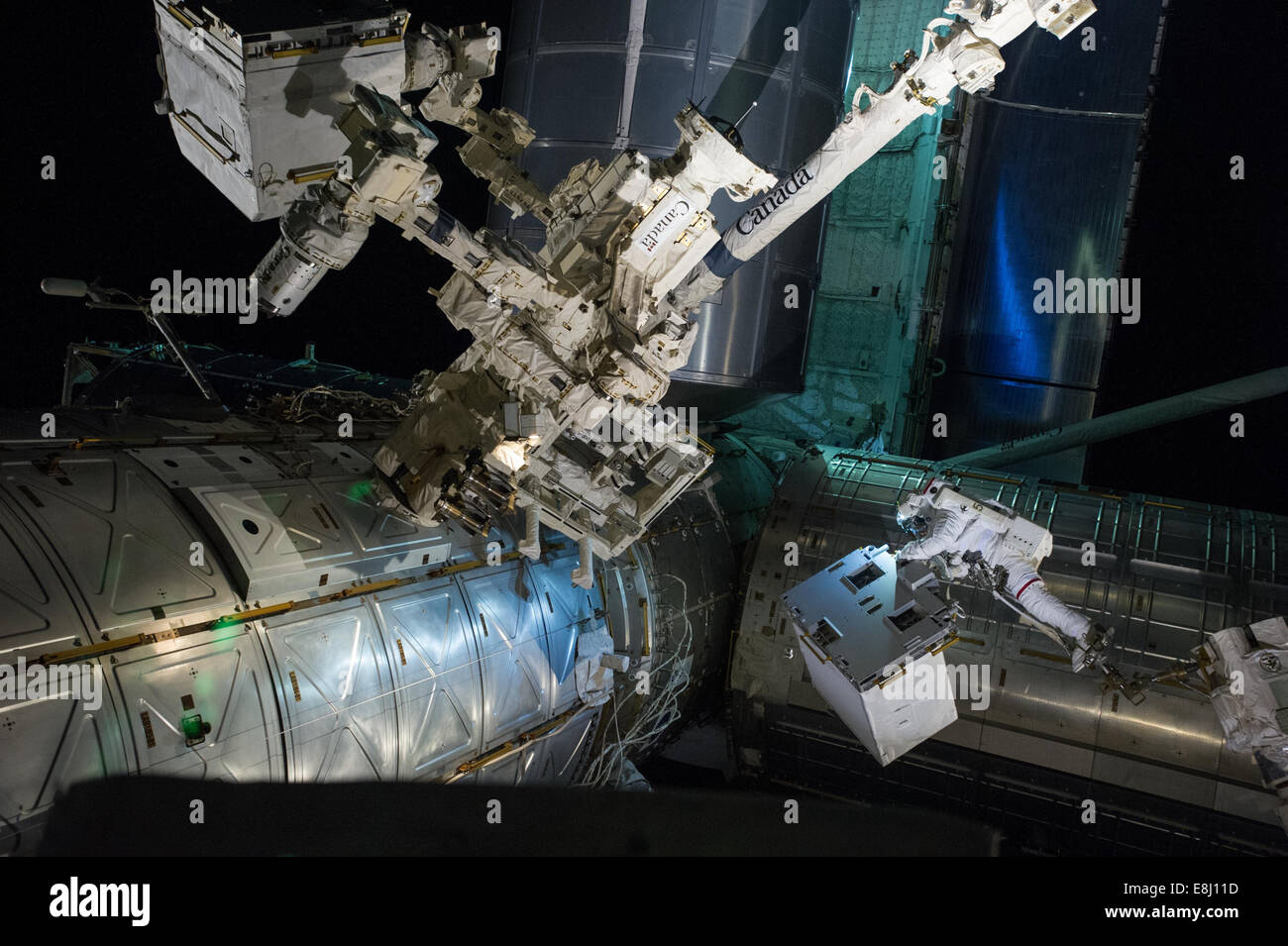 With the space shuttle docked in the background, an astronaut is ...