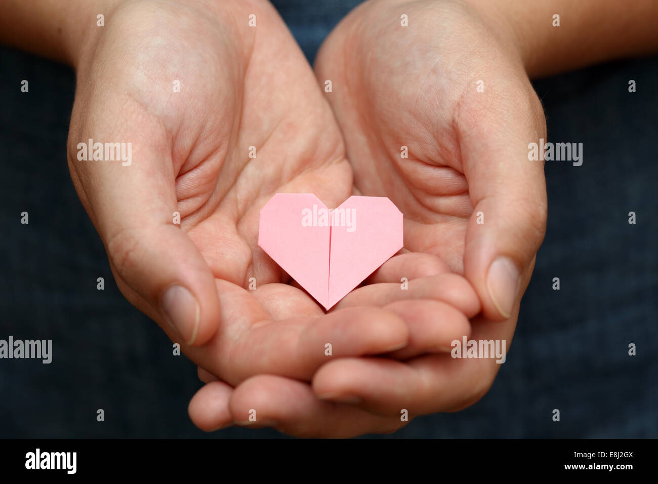 Origami heart in human hands Stock Photo - Alamy