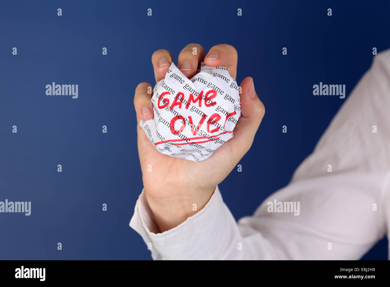 Crumpled paper ball with red words "Game over" and background with ...
