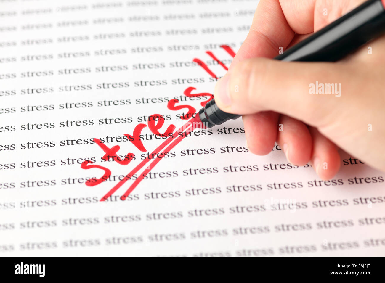 Woman's hand with red pen writing word "stress Stock Photo - Alamy