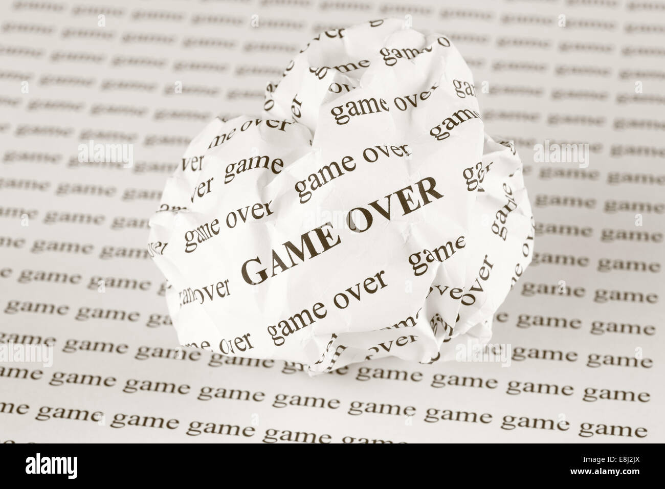 Crumpled paper ball with words "Game Over" on background with words ...