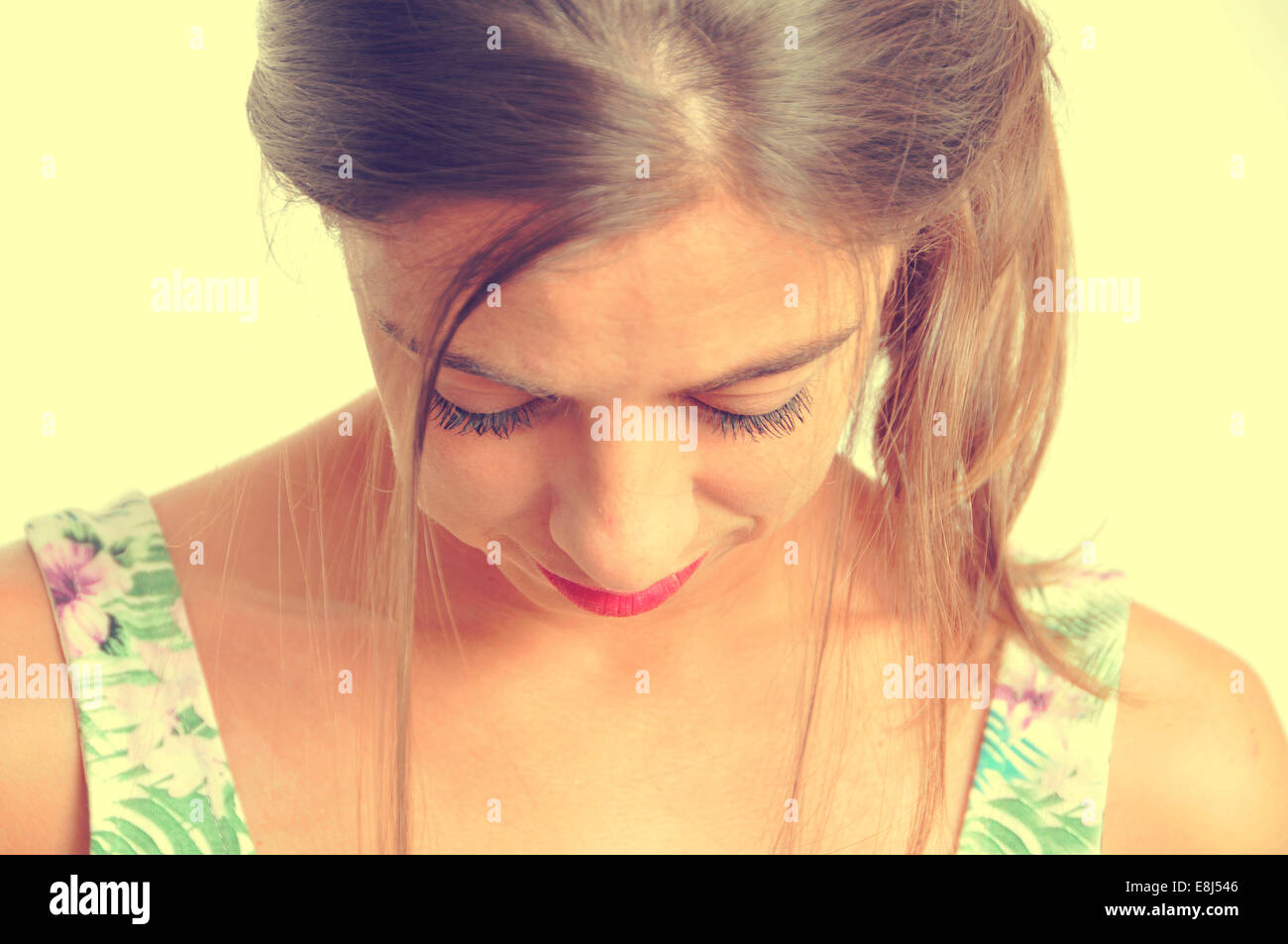 portrait of a young brunette woman looking downwards, with a retro ...