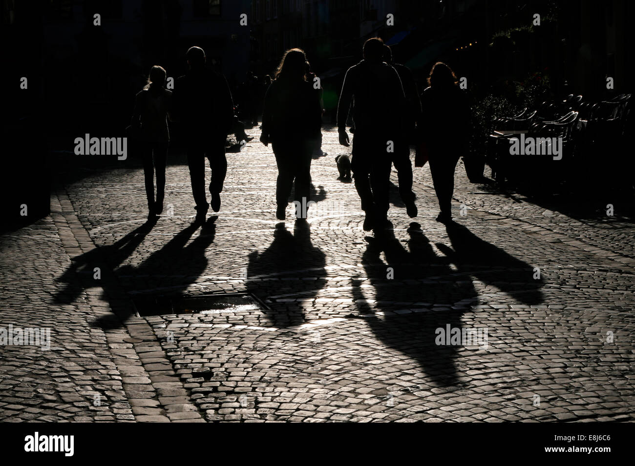 Pedestrians walking in the sunlight Stock Photo - Alamy