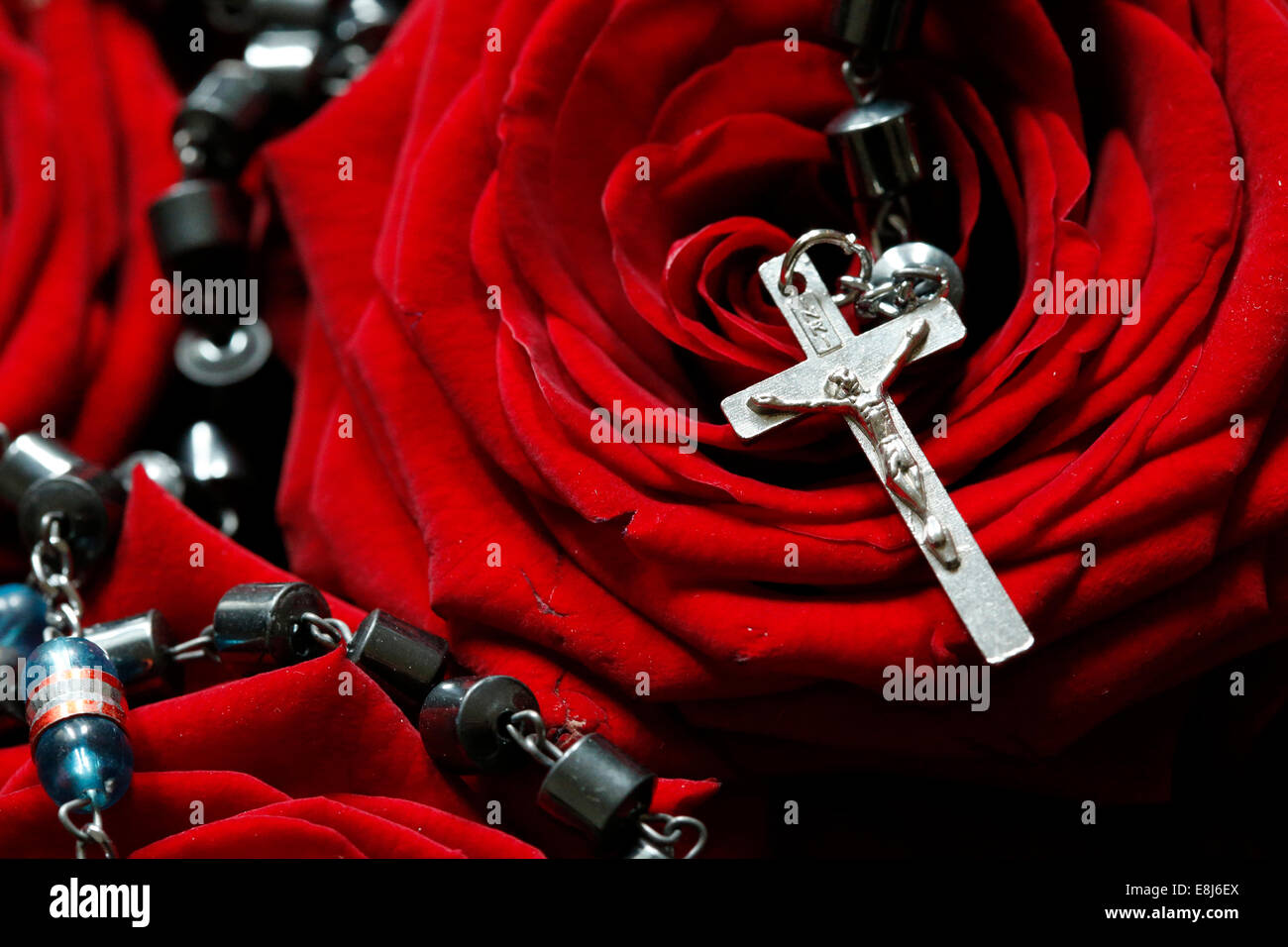 Crucifix on a bed of roses Stock Photo - Alamy