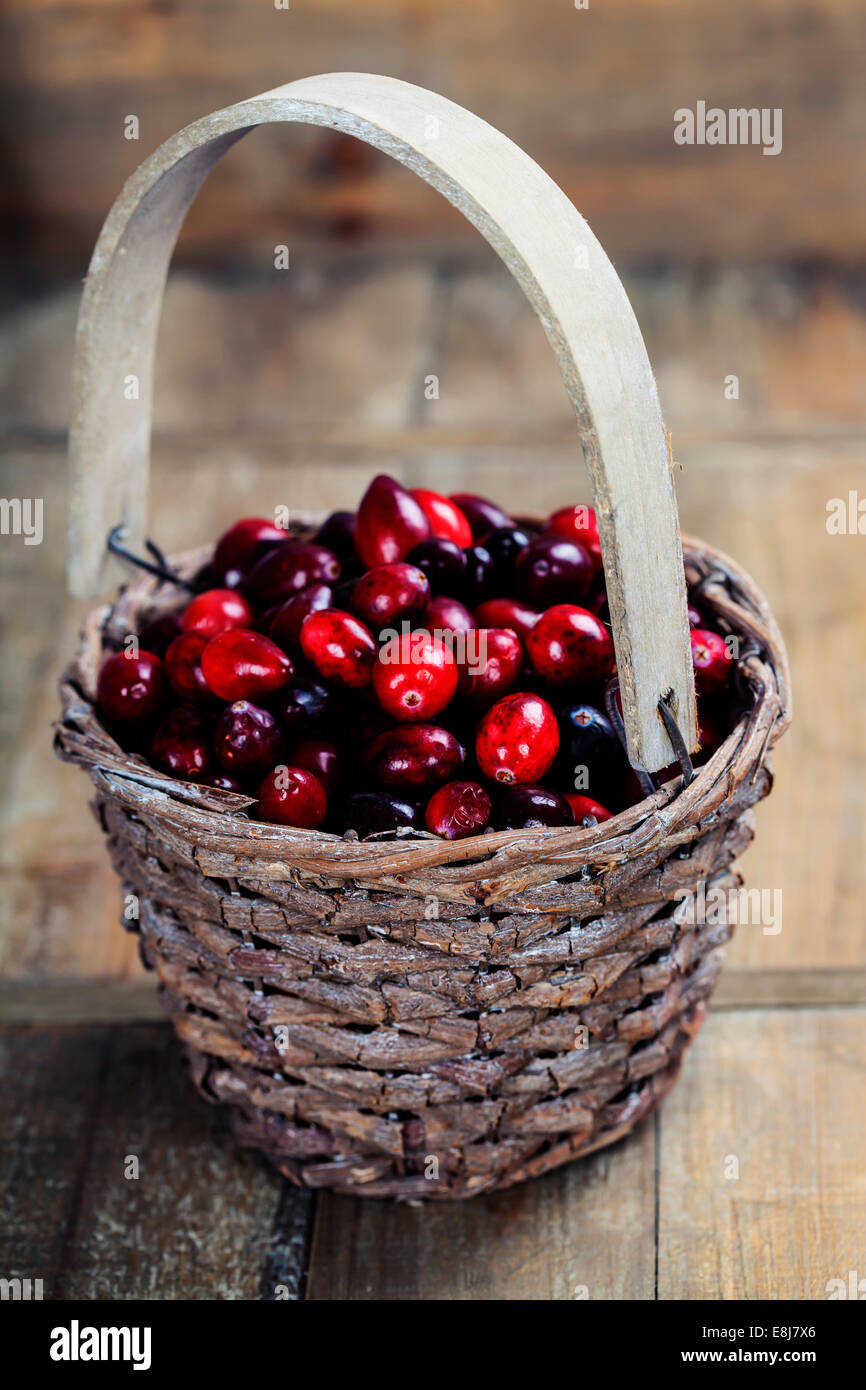 Ripe red cranberries in basket on wooden background Stock Photo - Alamy