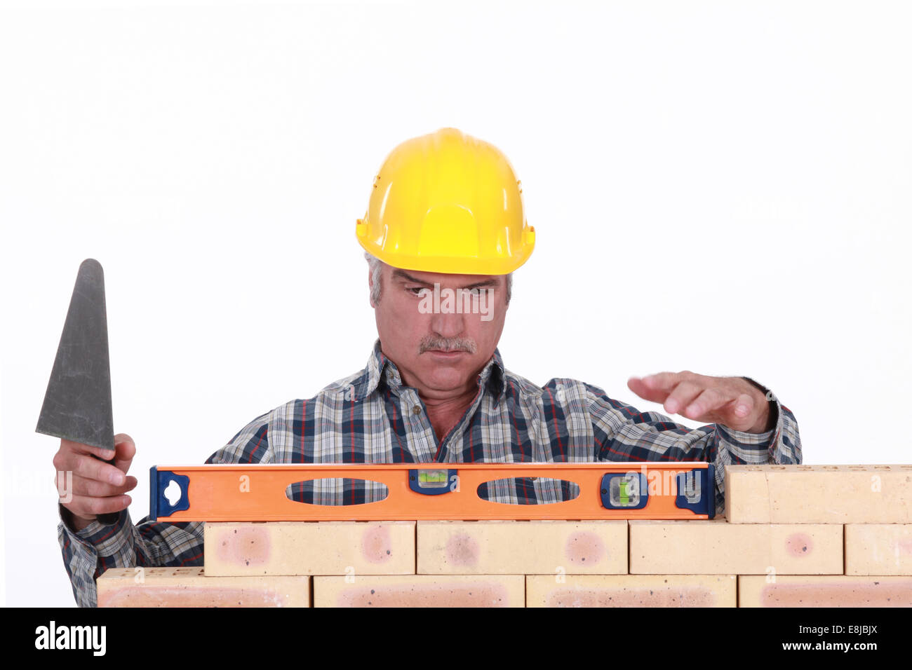 Mason leveling brick wall Stock Photo - Alamy