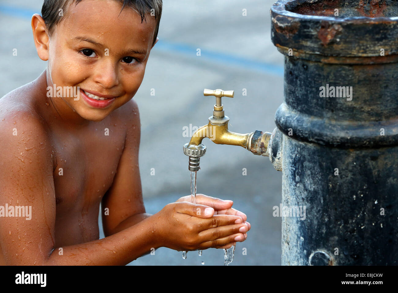 Boy taking water from a fountain Stock Photo - Alamy