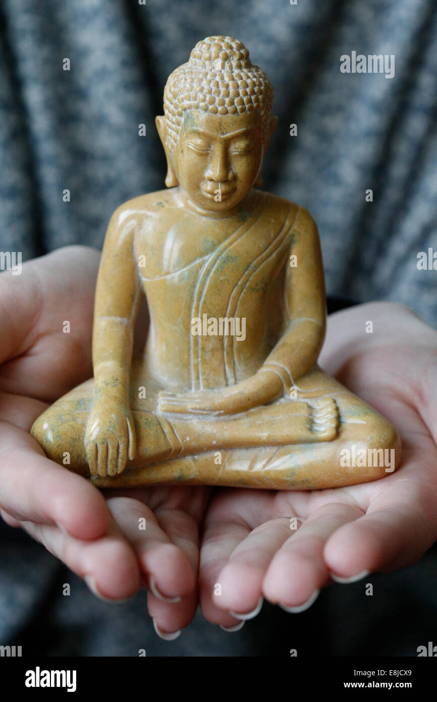 Hands carrying a statue of Buddha Stock Photo - Alamy