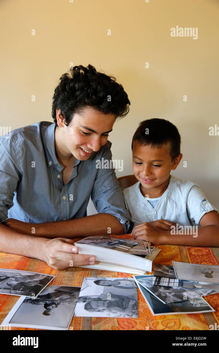 Brothers looking at photographs Stock Photo - Alamy