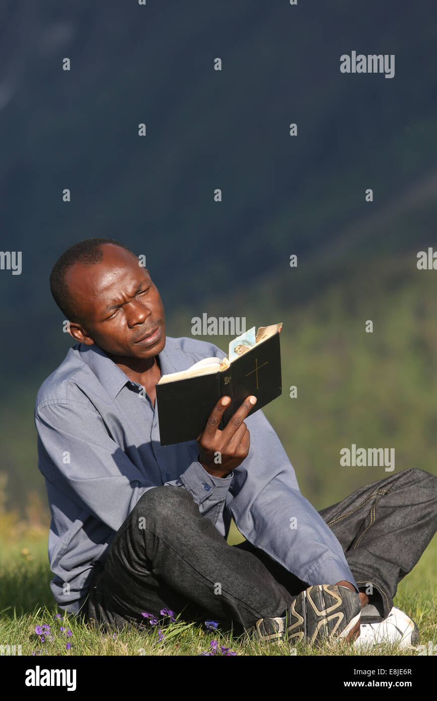 Man reading the bible outside Stock Photo - Alamy