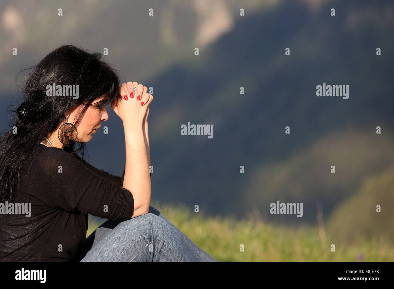 Woman praying outside Stock Photo - Alamy