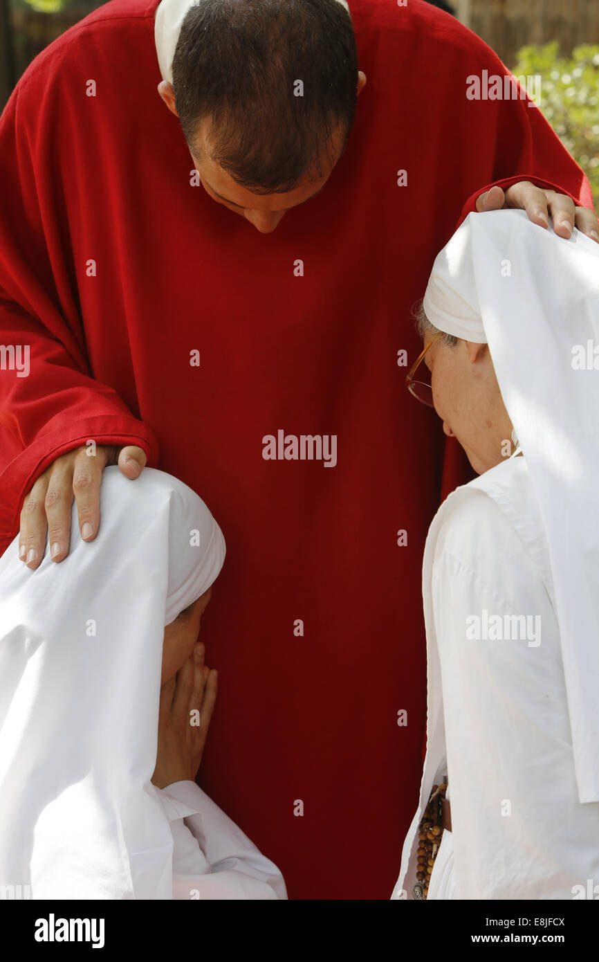 Newly ordained catholic priest blessing nuns Stock Photo - Alamy