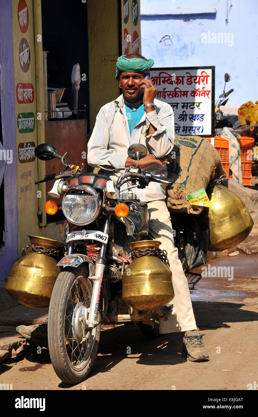 Milk collector carrying milk-churns on his motorbike Stock Photo - Alamy