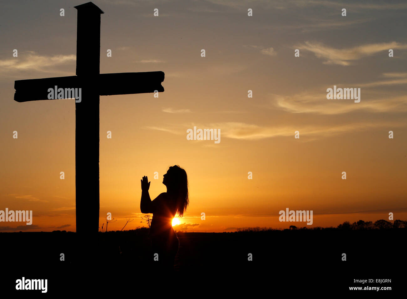 Woman praying at sunset Stock Photo - Alamy