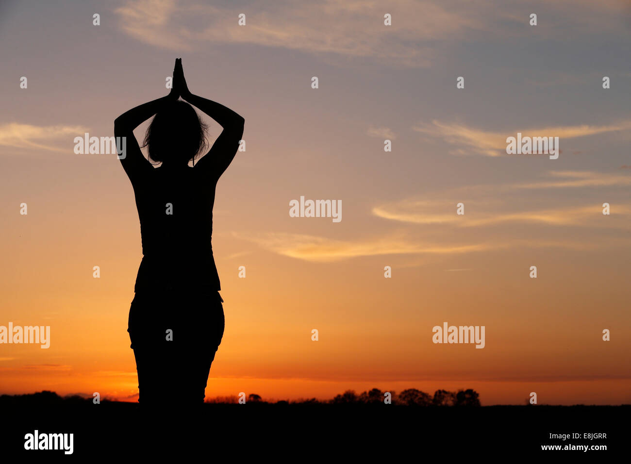 Woman praying at sunset Stock Photo - Alamy