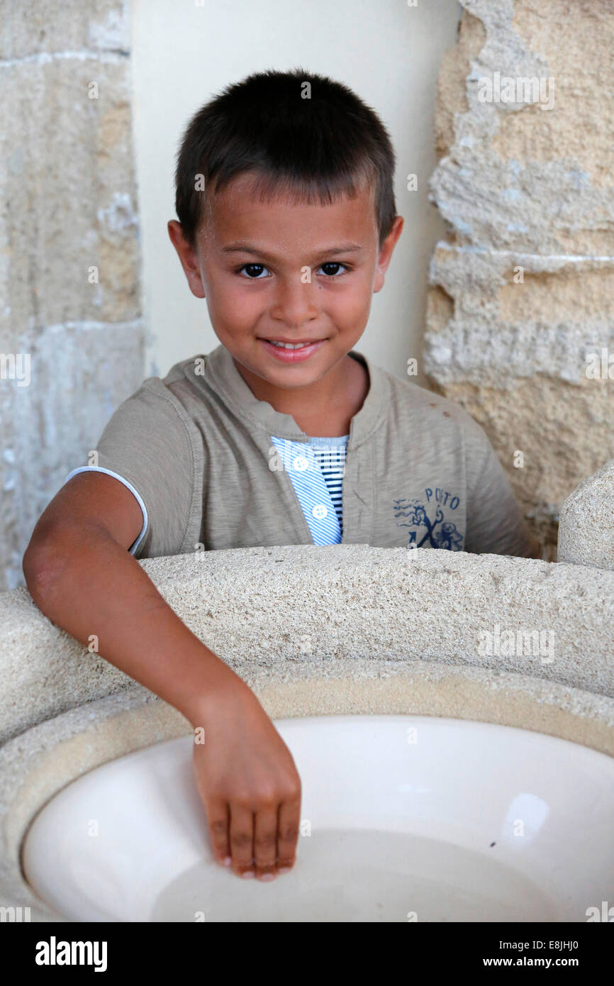 Boy taking holy water from a font Stock Photo - Alamy