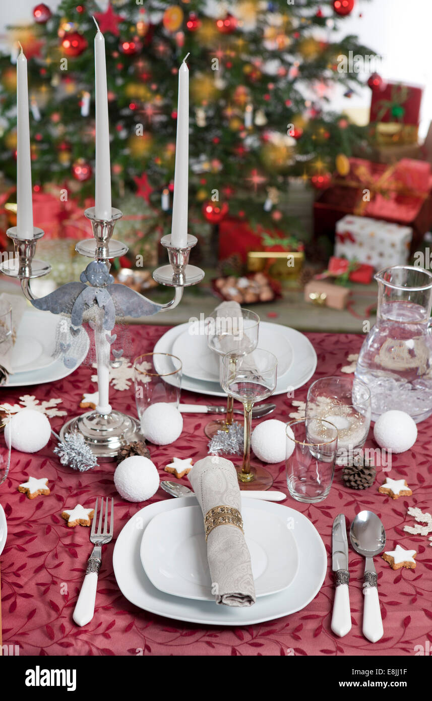 Festive table with Christmas tree in the background Stock Photo - Alamy